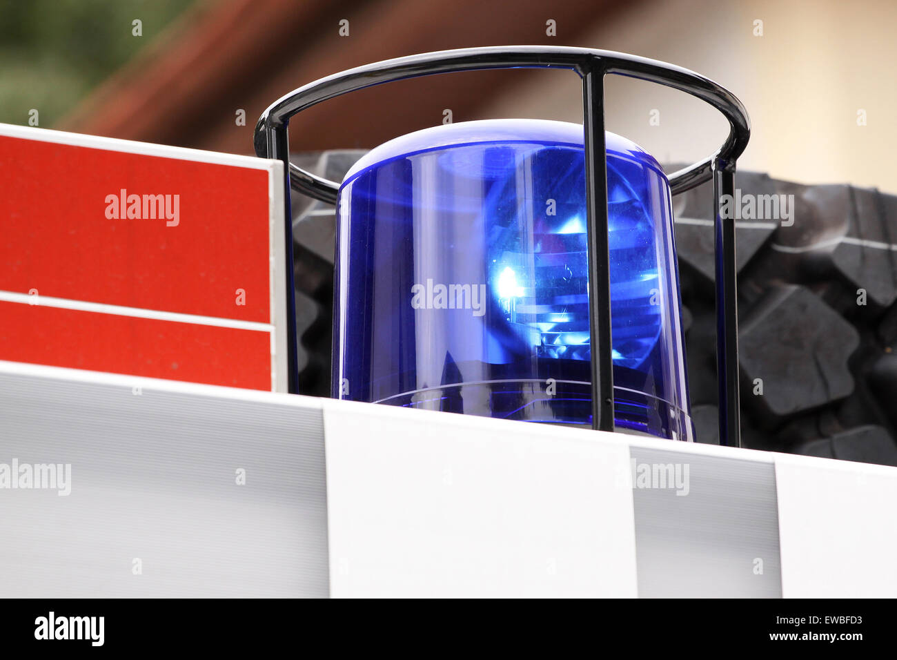 Fire engine blue flashing light with firemen working behind Stock Photo ...