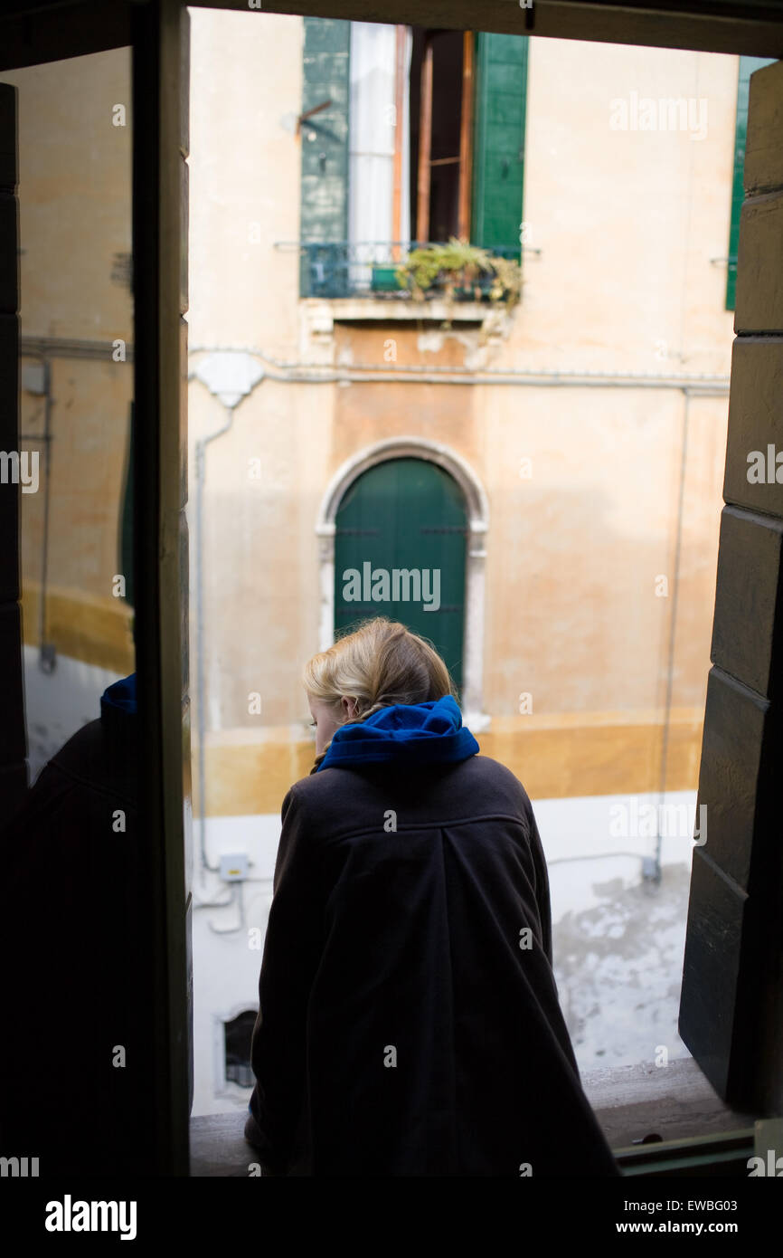 Venice, Italy. Young girl leaning out of window Stock Photo - Alamy