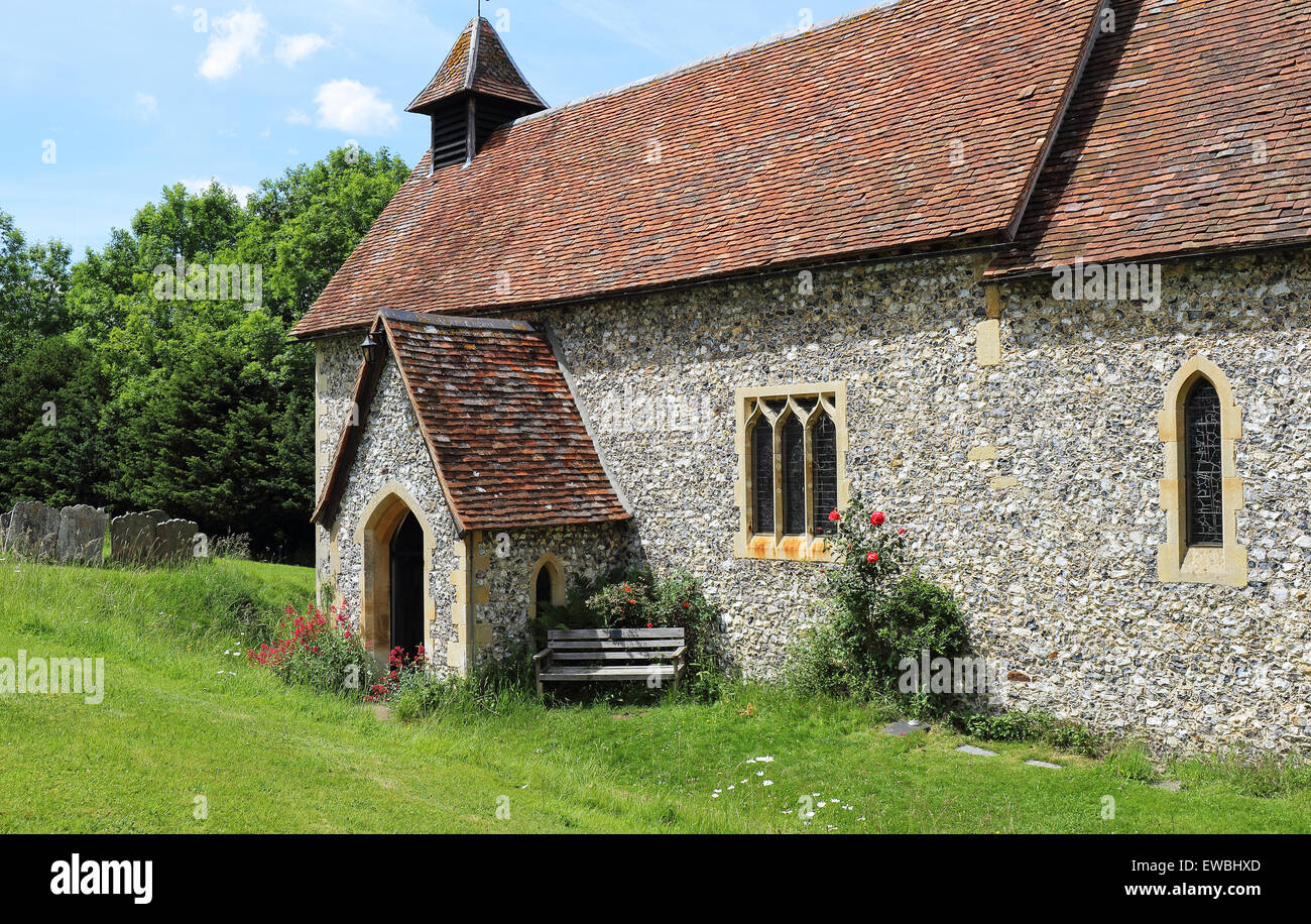 Medieval English Village Church with bench seat and flowers around the ...