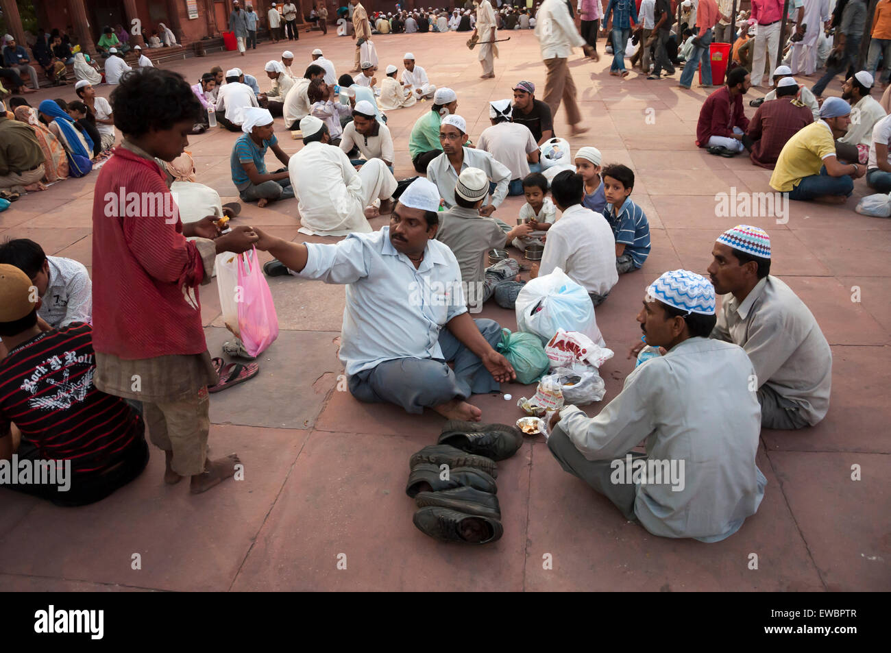 A man hands over food to a child during traditional Iftar (fast ...