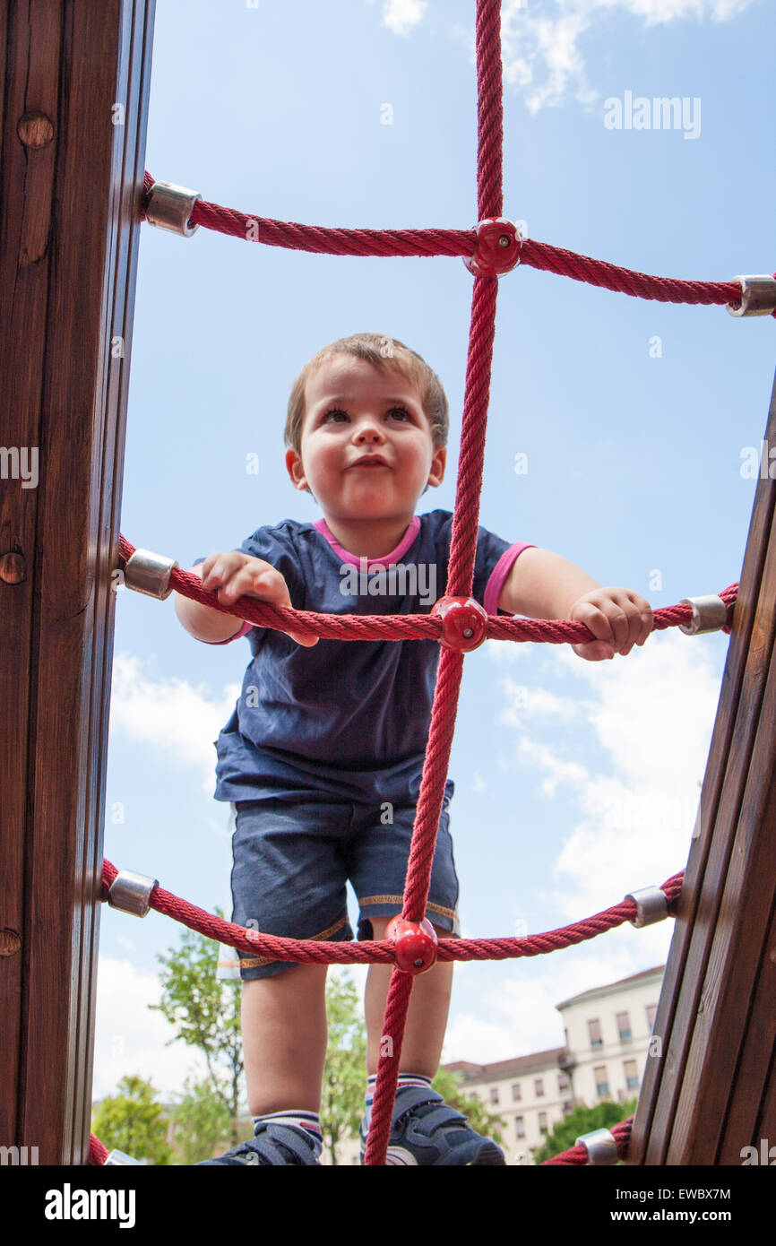 portrait of child climbing ropes in a playground Stock Photo - Alamy