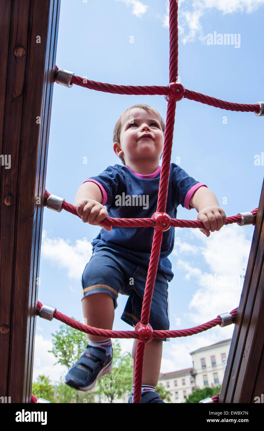 portrait of child climbing ropes in a playground Stock Photo - Alamy