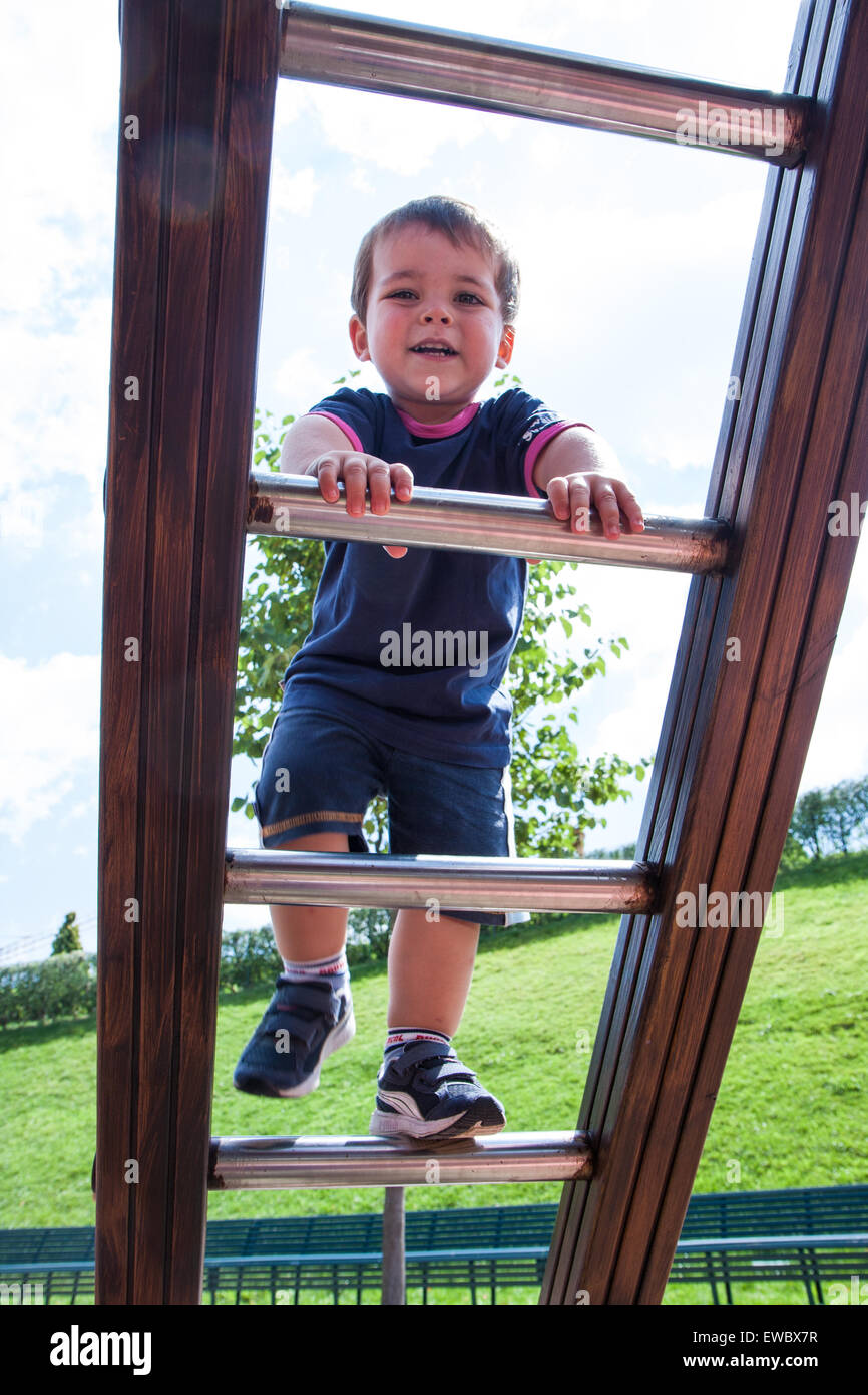 portrait of child climbing ropes in a playground Stock Photo - Alamy
