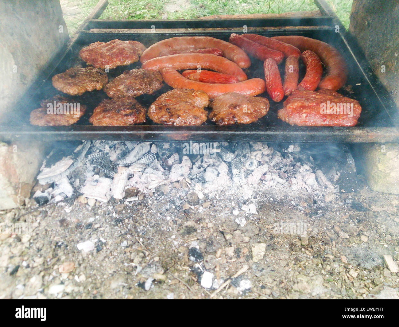 Outdoor Grilling with Campfire. Preparing a batch of ground beef ...