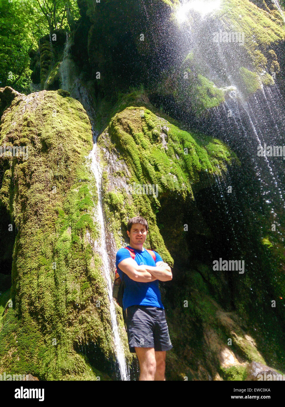 Man standing by beautiful waterfall in Romania. Male jungle hiker under ...