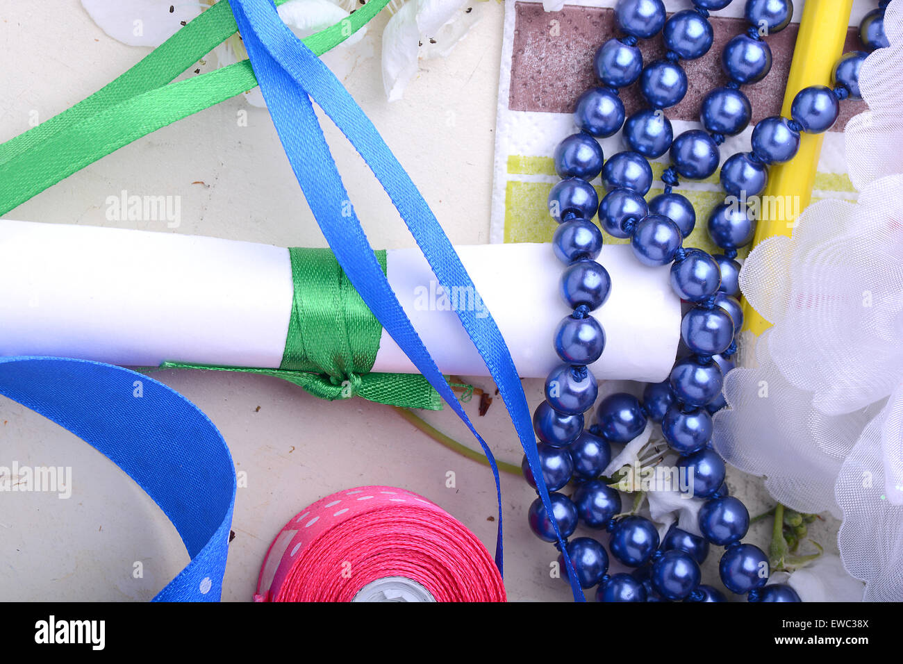 Office table with flower, ribbons, pencils, pearls Stock Photo - Alamy