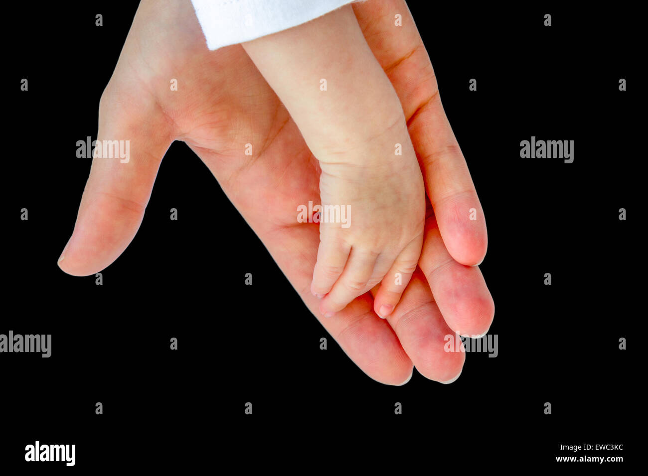 Hand of mother carrying arm of newborn baby isolated on black ...