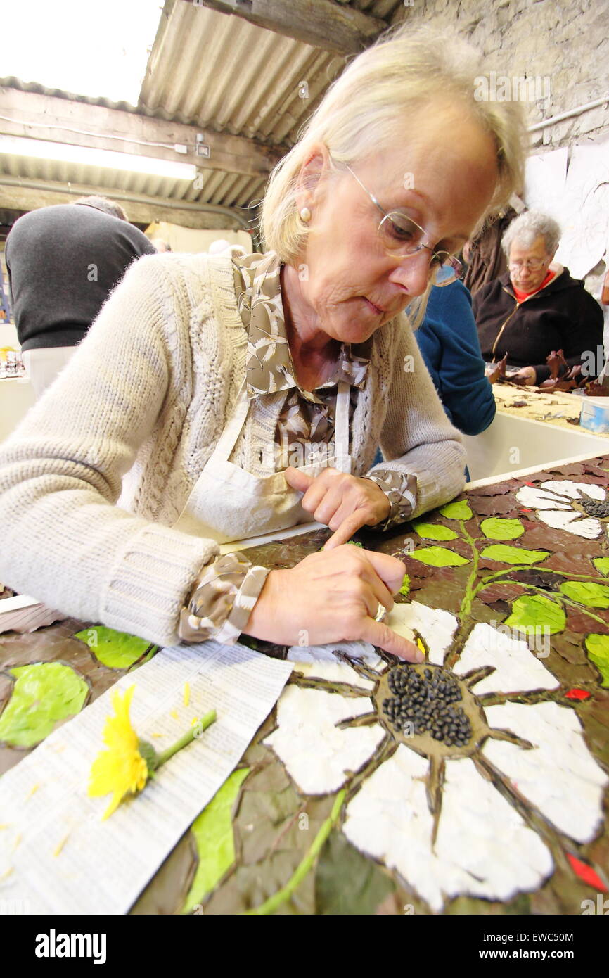 Volunteers prepare a well dressing with natural materials ahead of its ...