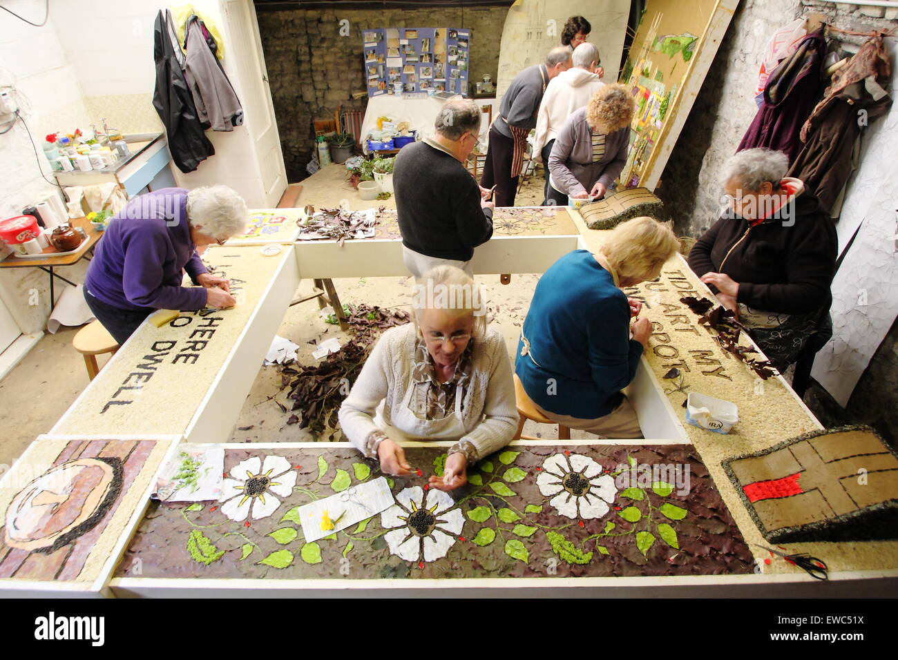 Volunteers prepare a well dressing with natural materials ahead of its ...