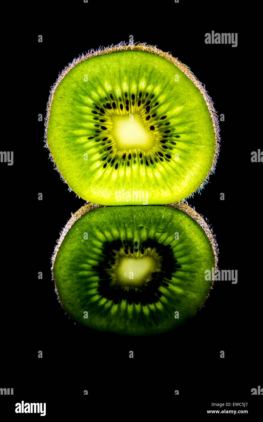Kiwi fruit slice backlit with reflection on black back ground Stock ...