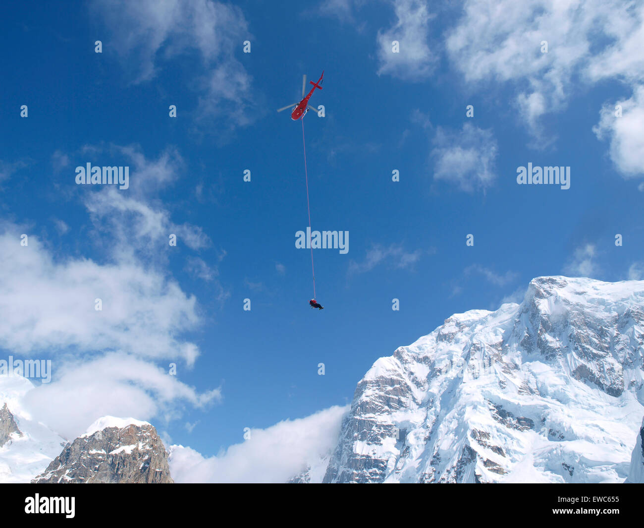 Mountain Ranger is hanging on a long line underneath a helicopter in ...