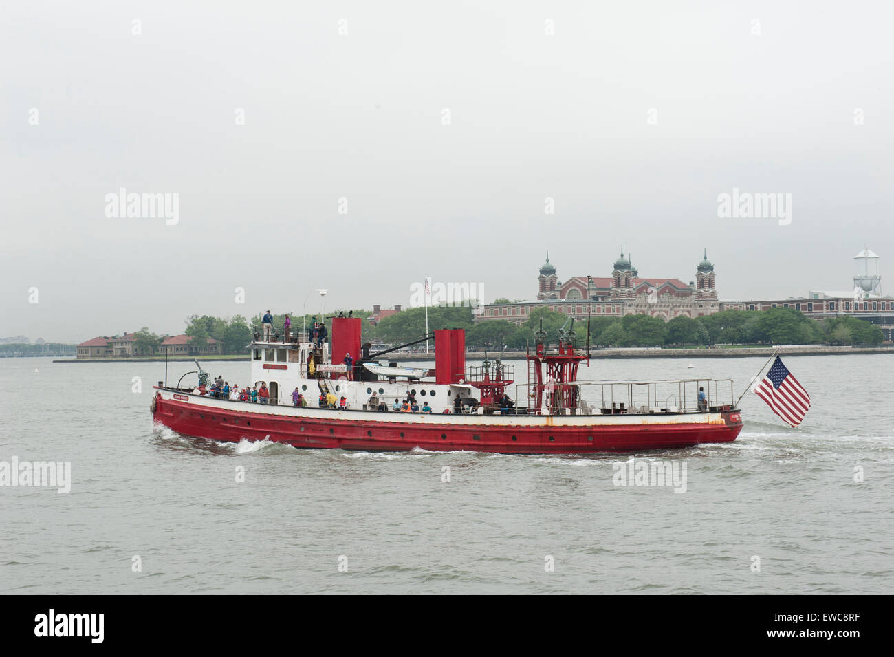 The landmarked fireboat John J. Harvey passing Ellis Island in New York ...