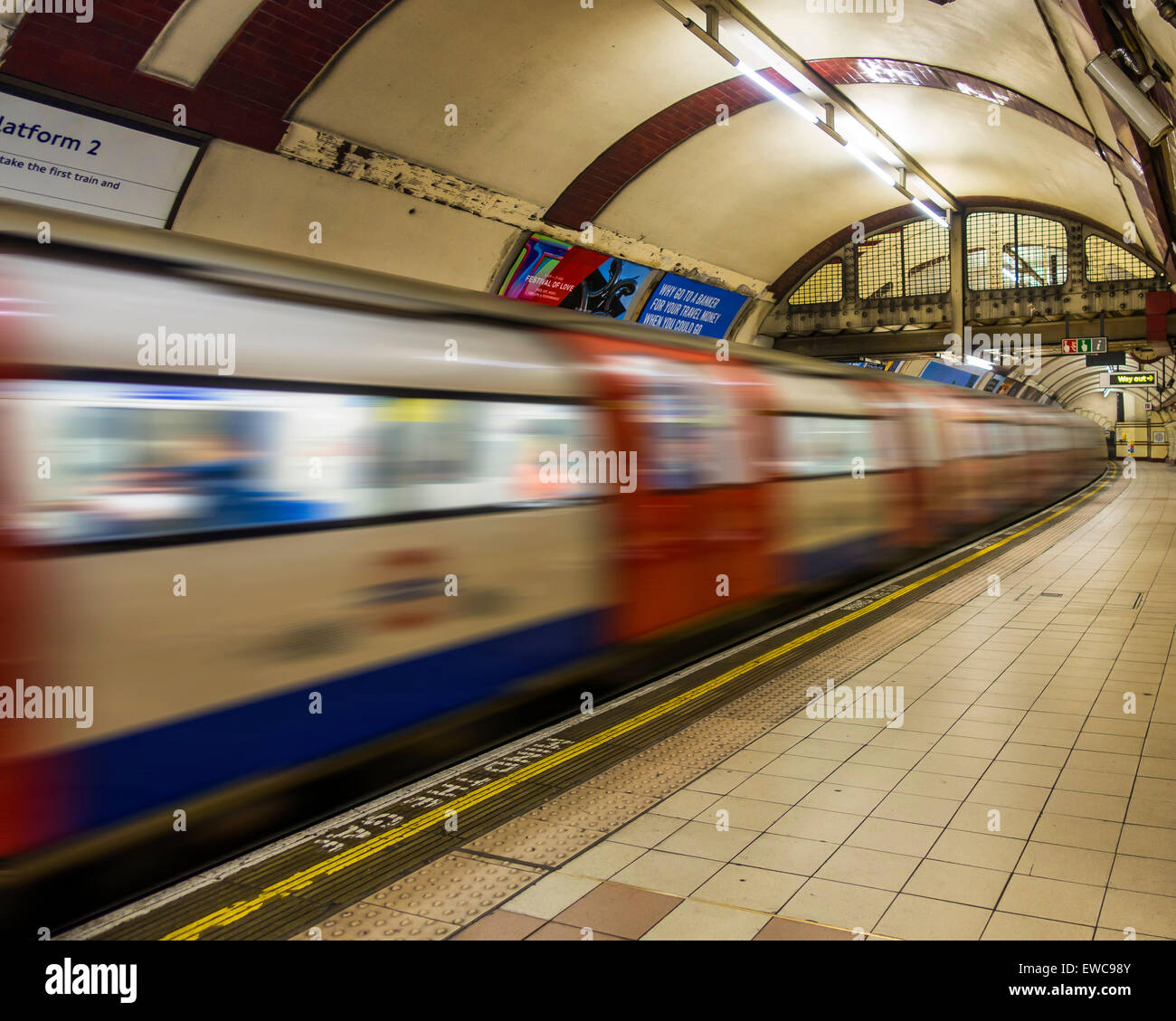 London Underground train traveling through station Stock Photo - Alamy