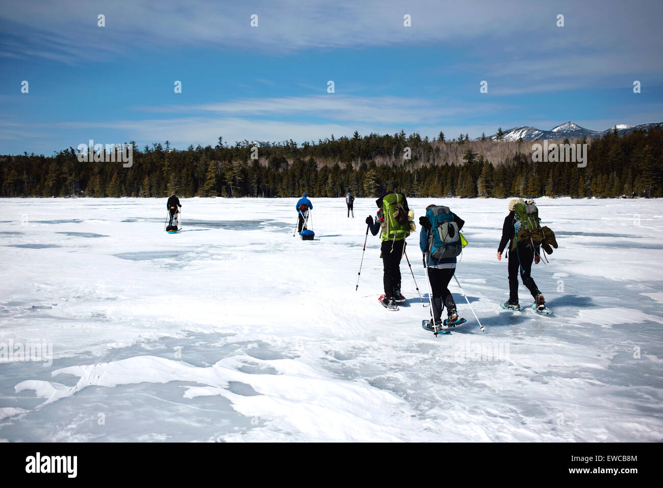 A group of winter hikers crossing a frozen pond Stock Photo - Alamy