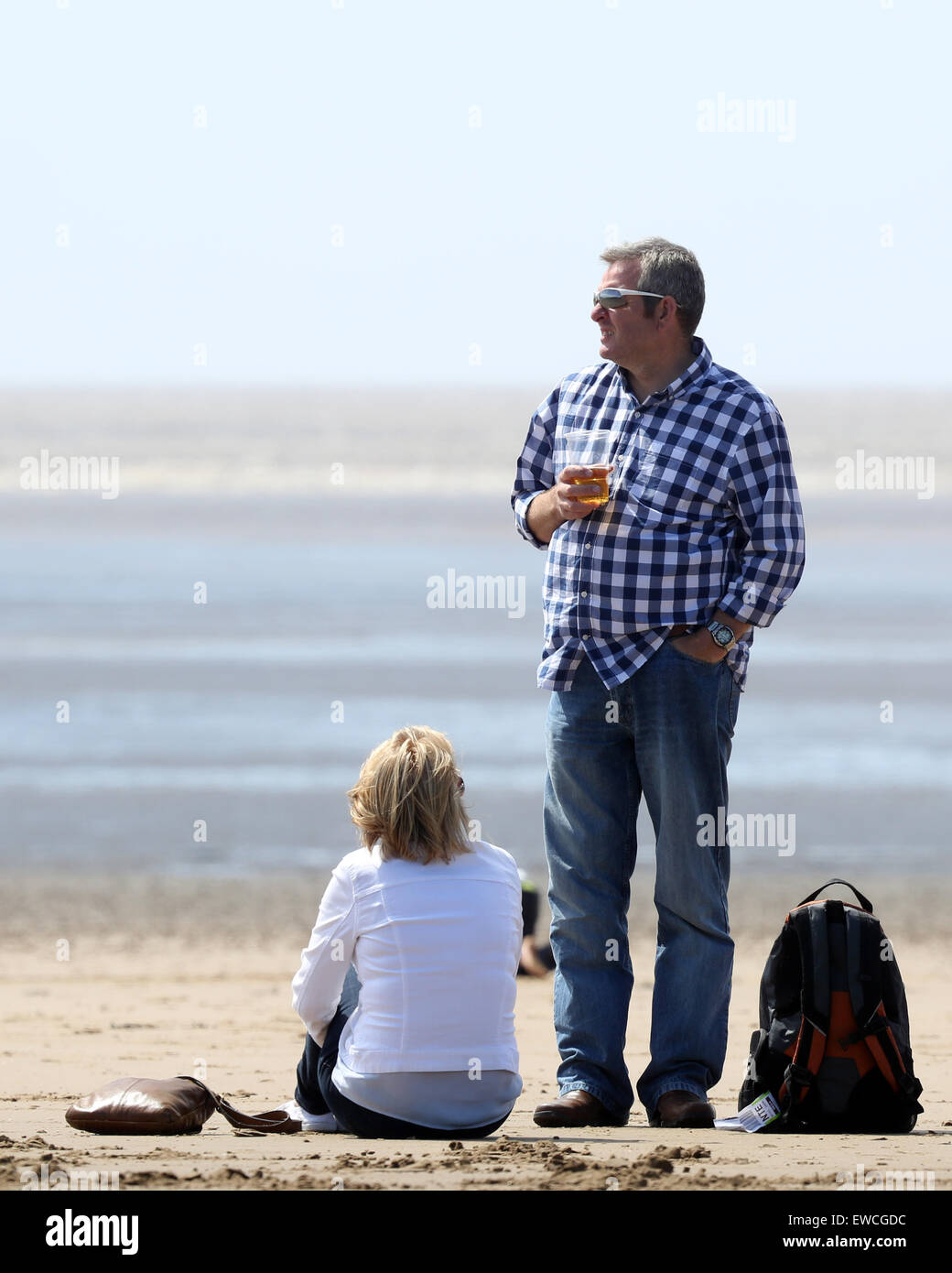 Man enjoying a pint of beer from a glass on the beach at Weston super ...