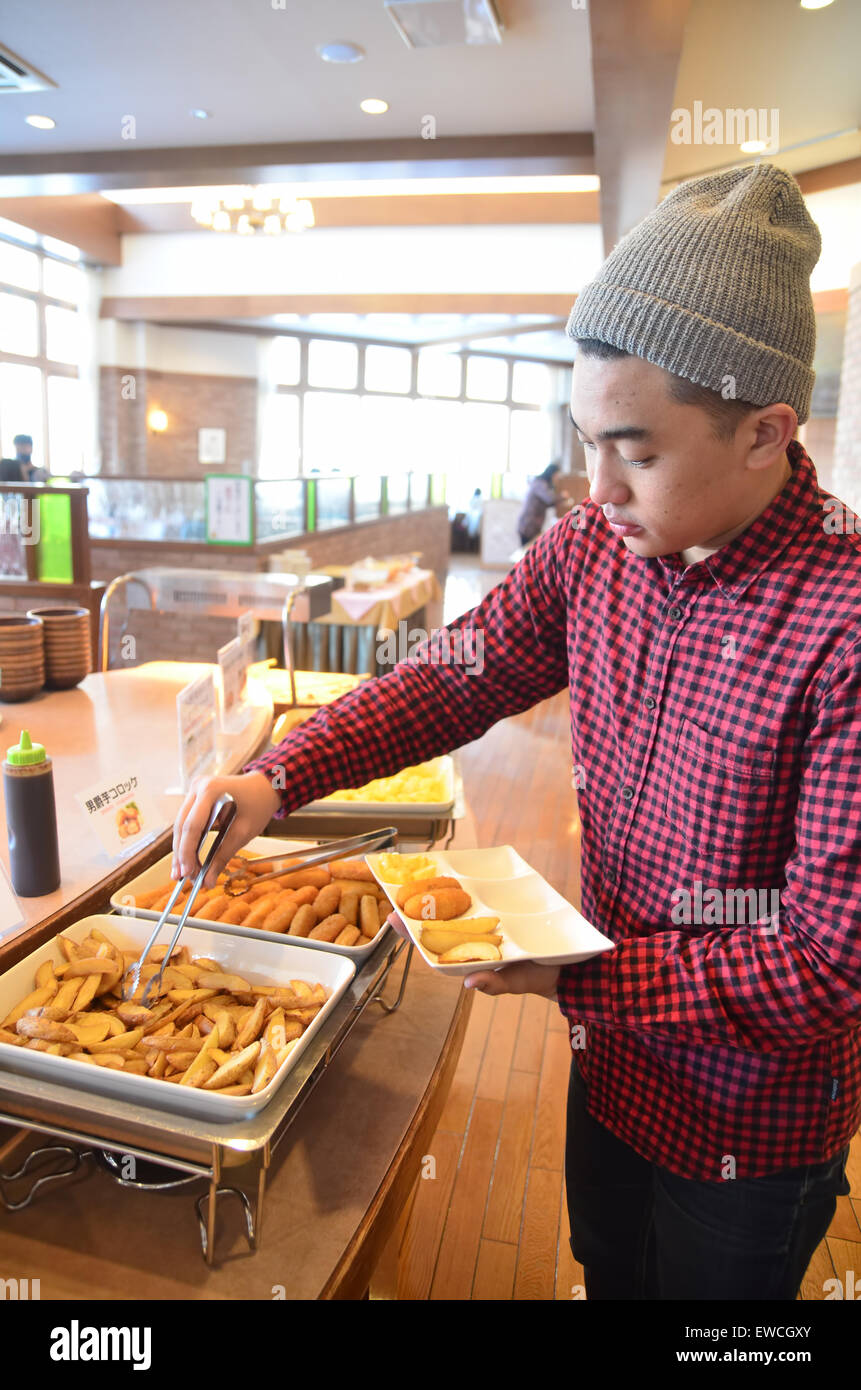 Teenage boy taking some foods for breakfast in Taisetsu Hotel Stock ...
