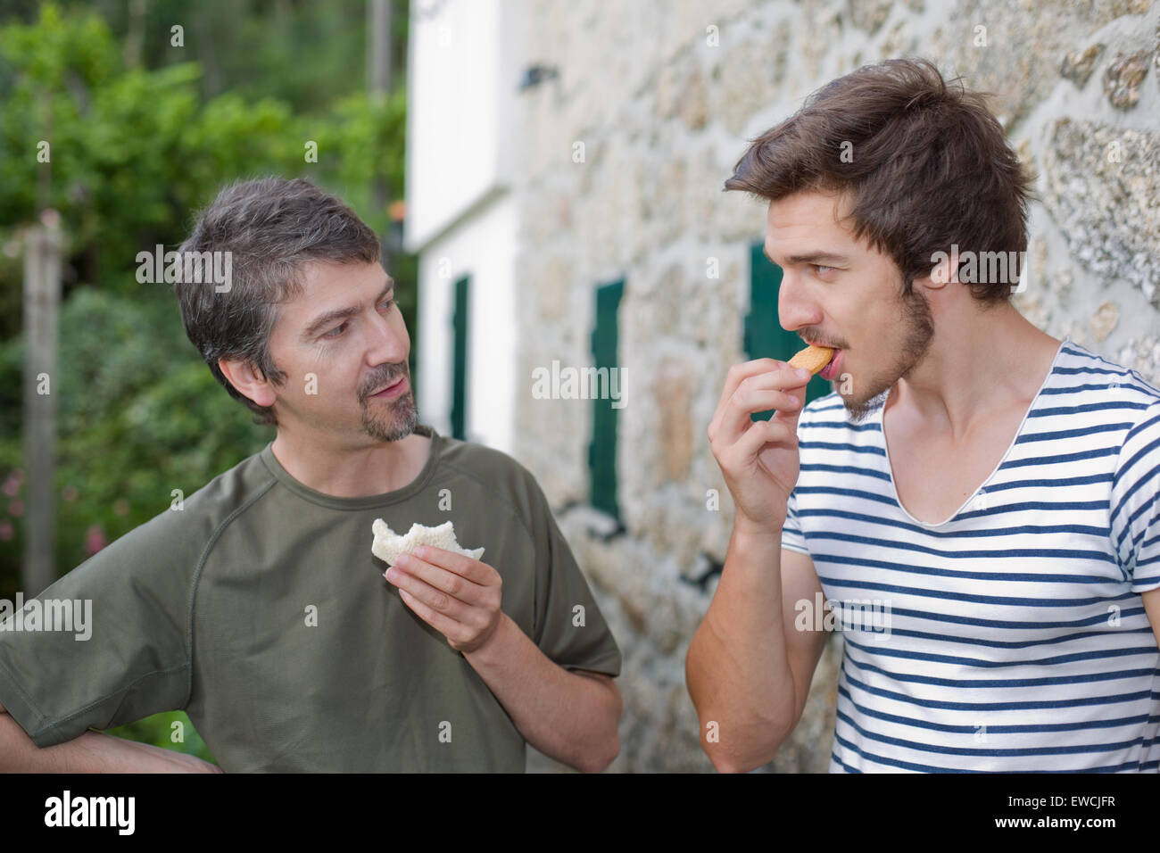 two friends having a snack and talking outdoors Stock Photo - Alamy