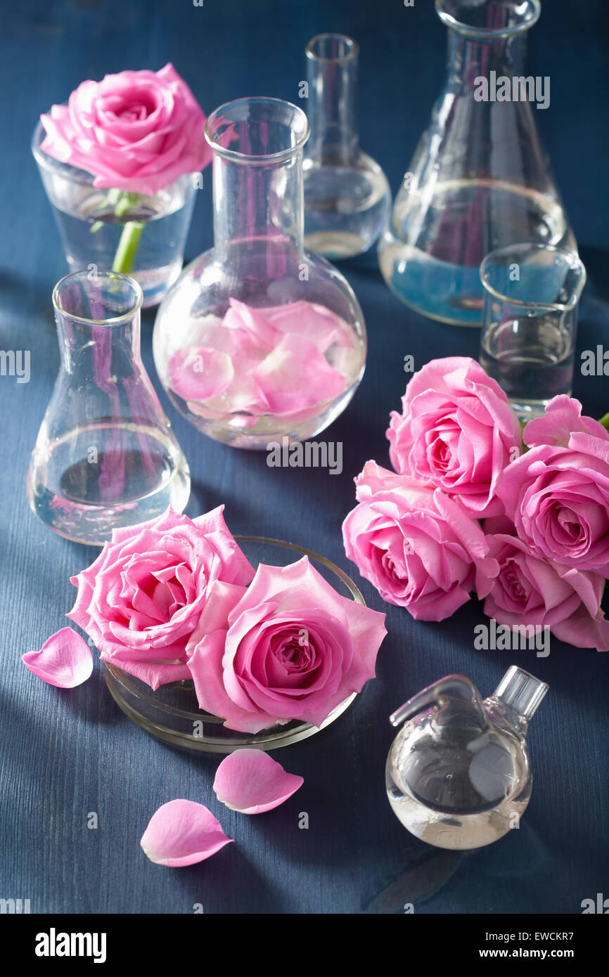 alchemy and aromatherapy set with rose flowers and chemical flasks ...