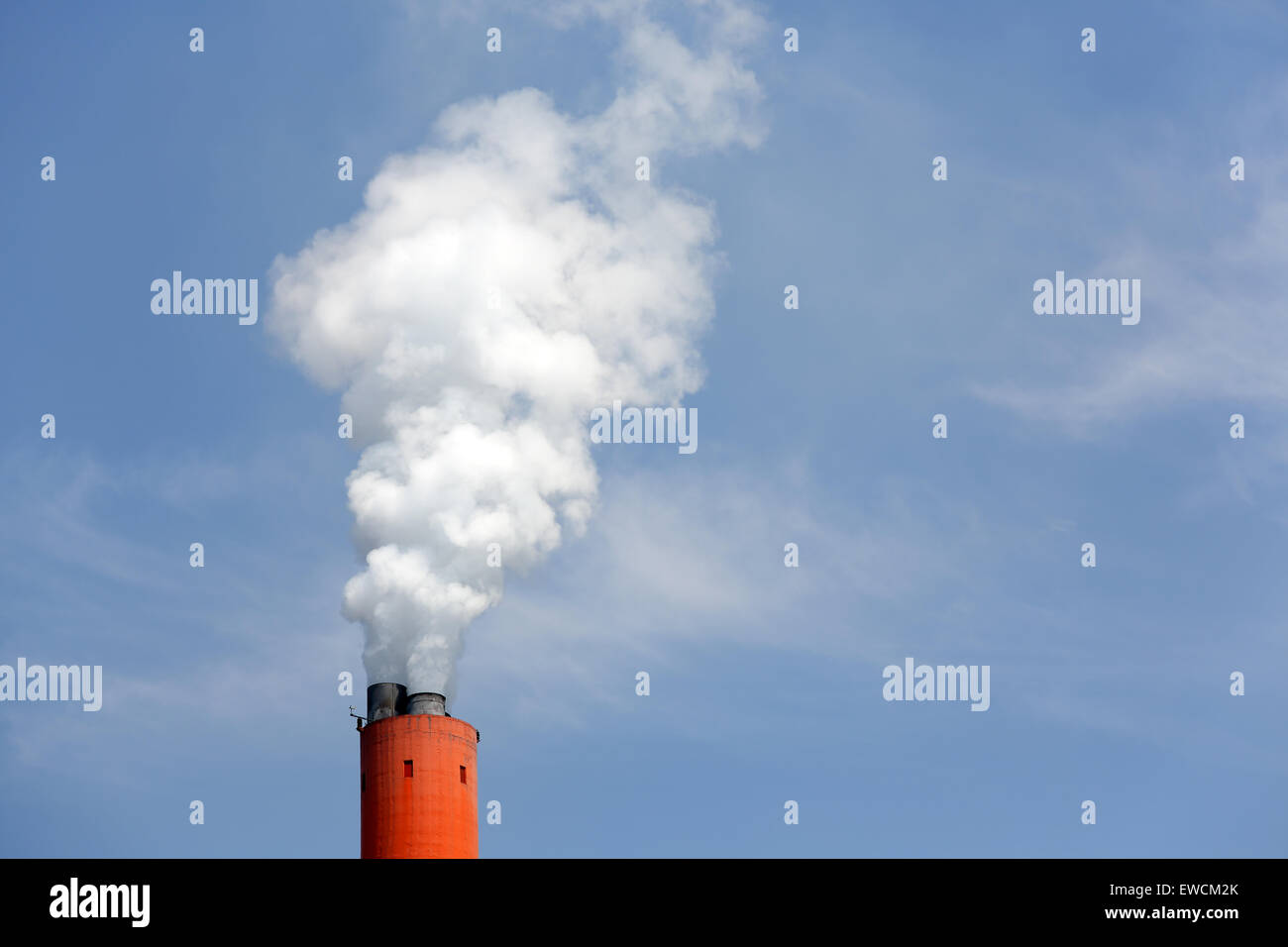 Smoke stack with smoke on blue sky background Stock Photo - Alamy