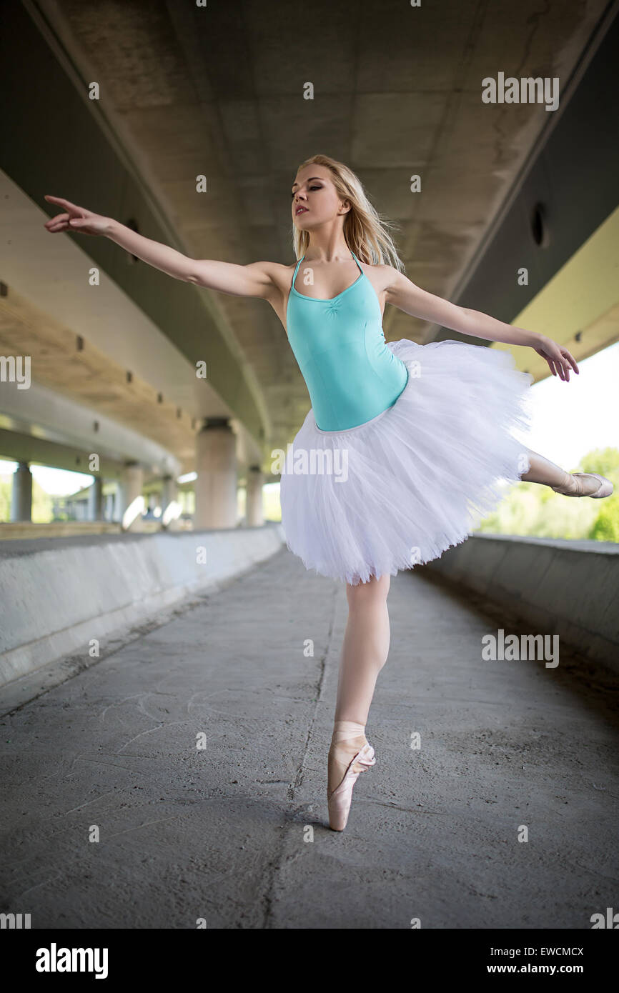 Graceful ballerina doing dance exercises on a concrete bridge Stock ...