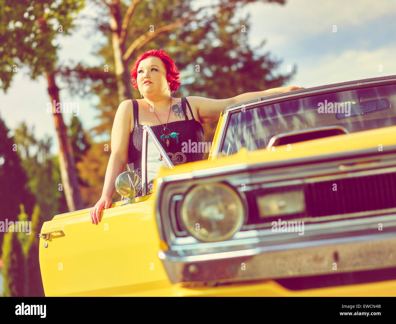 Beautiful young woman posing, old Dodge - 70's theme, intentional film ...
