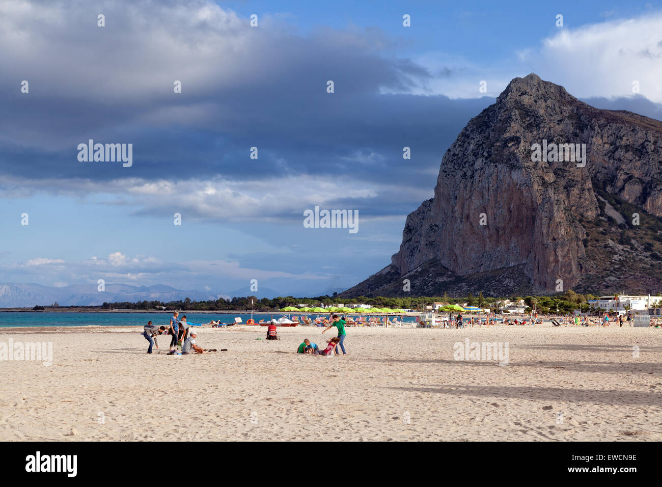 Tourists enjoying late october sun on a sandy beach at San Vito Lo Capo ...