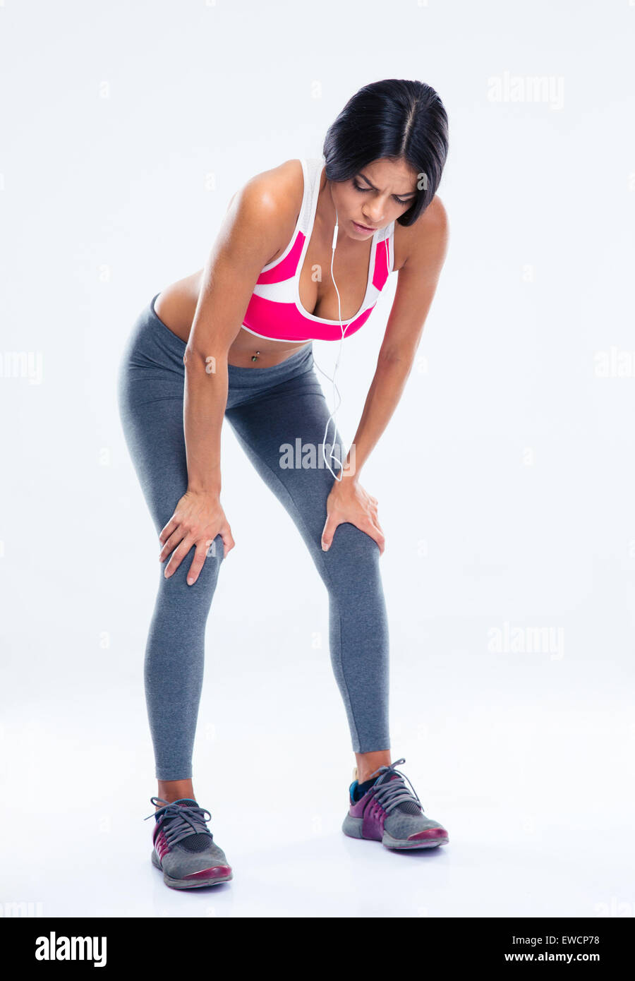 Full length portrait of a tired fitness woman resting over gray ...