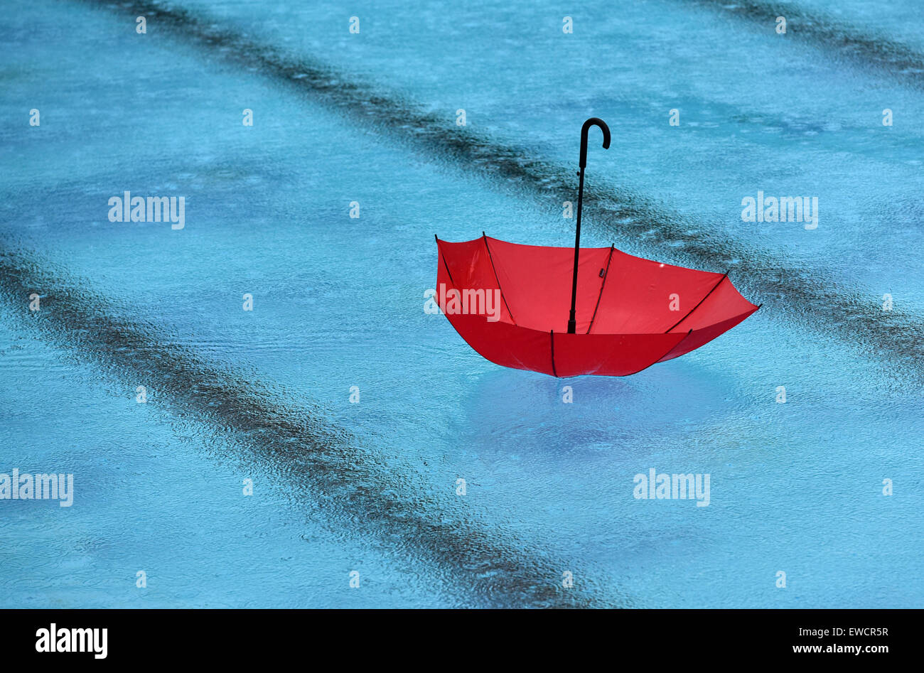 ILLUSTRATION - An umbrella floats in an outdoor pool in the pouring ...