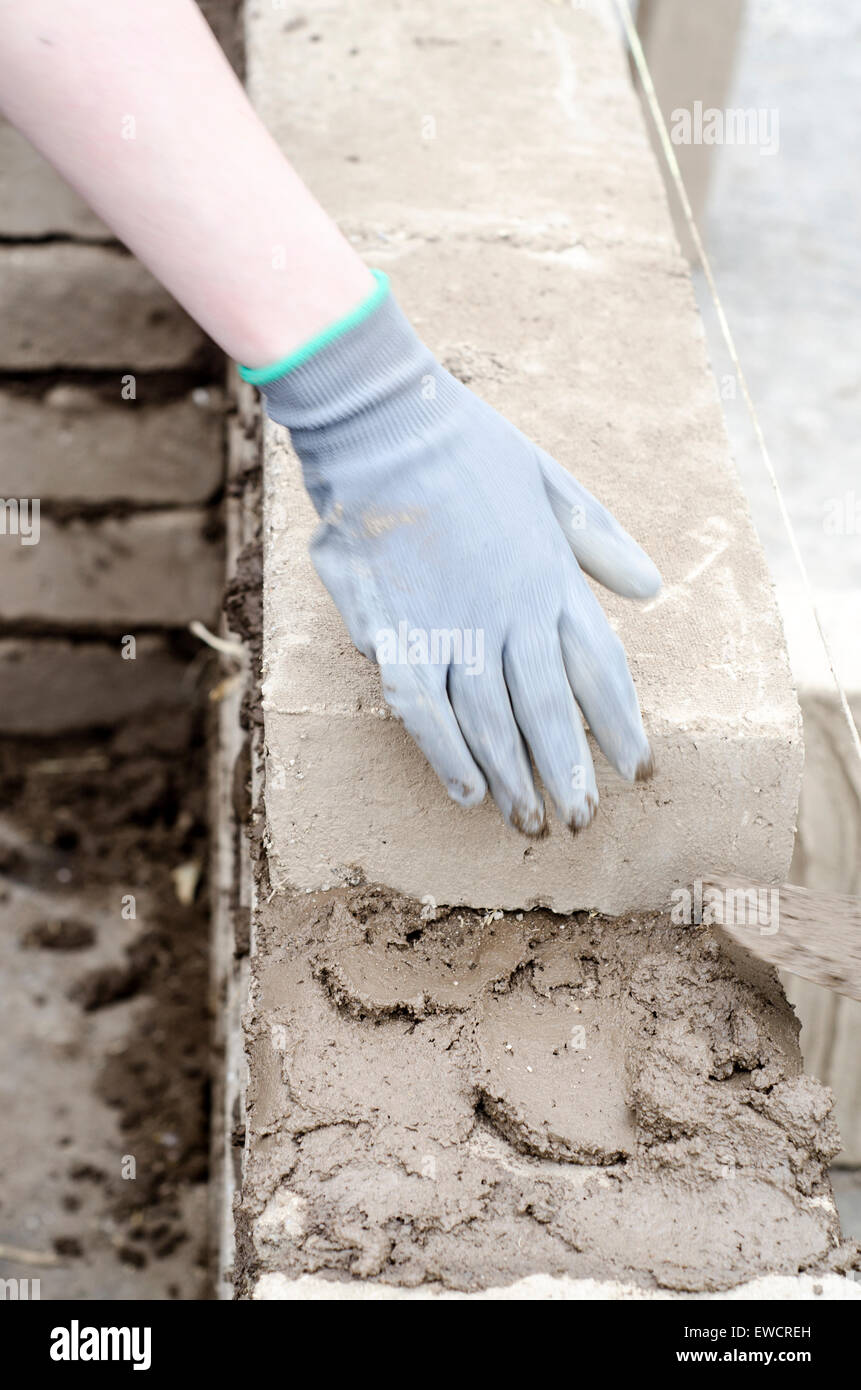 hand with glove positioning brick building wall and female arm Stock ...