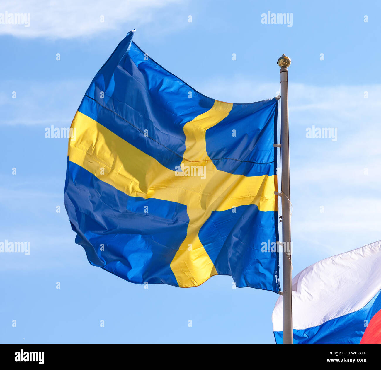 Flag of Sweden waving against blue sky Stock Photo - Alamy