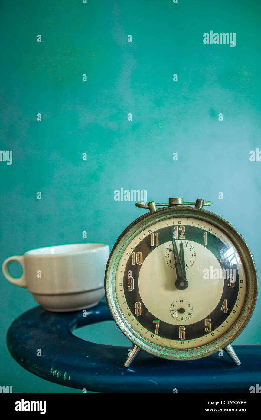 Old clock and coffee cup on a green background Stock Photo - Alamy