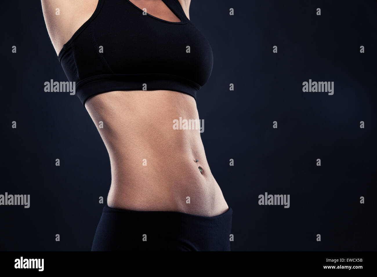 Closeup of a fit woman's abs isolated over black background Stock Photo ...