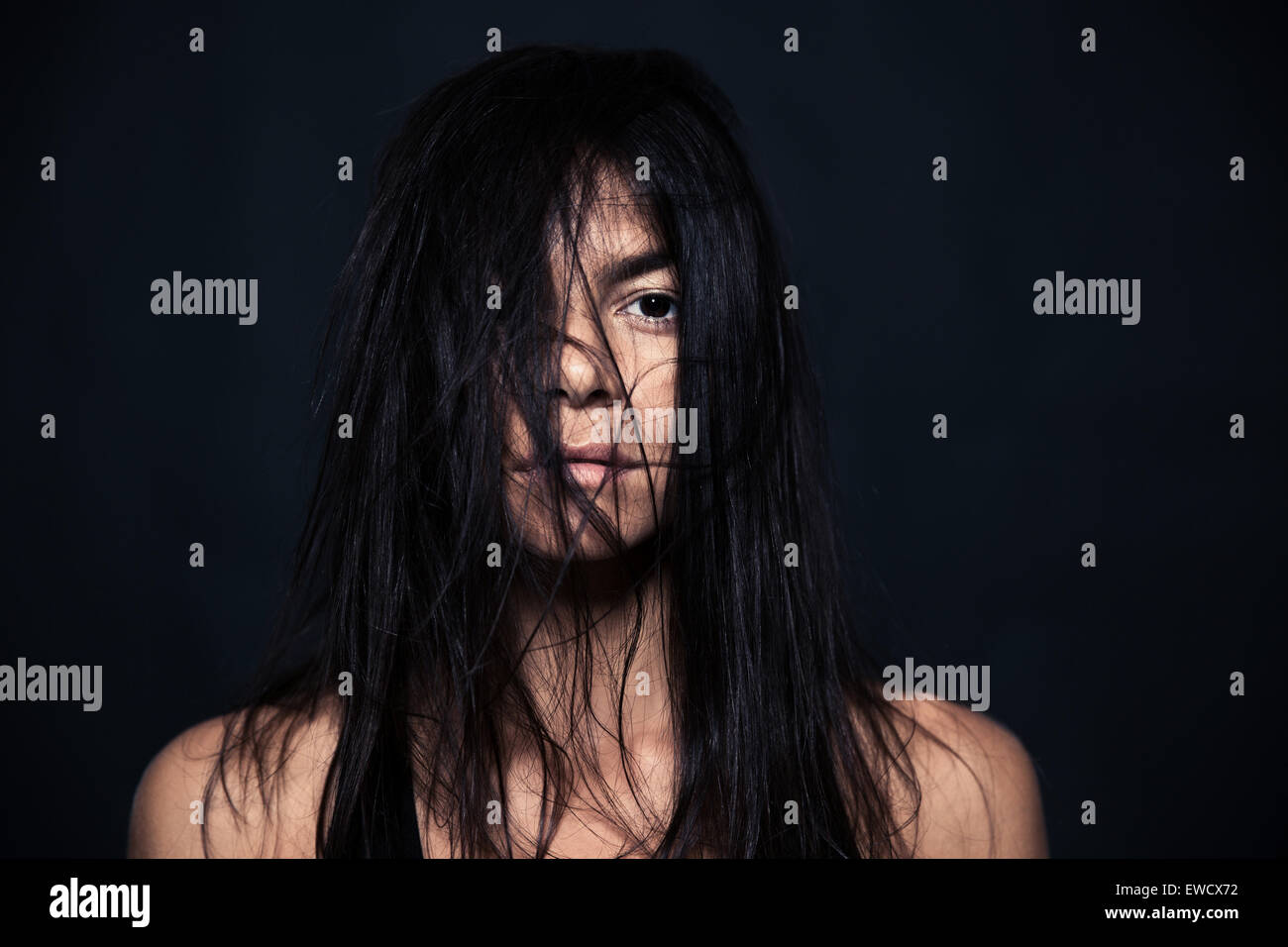 Portrait of tired woman standing over black background Stock Photo - Alamy