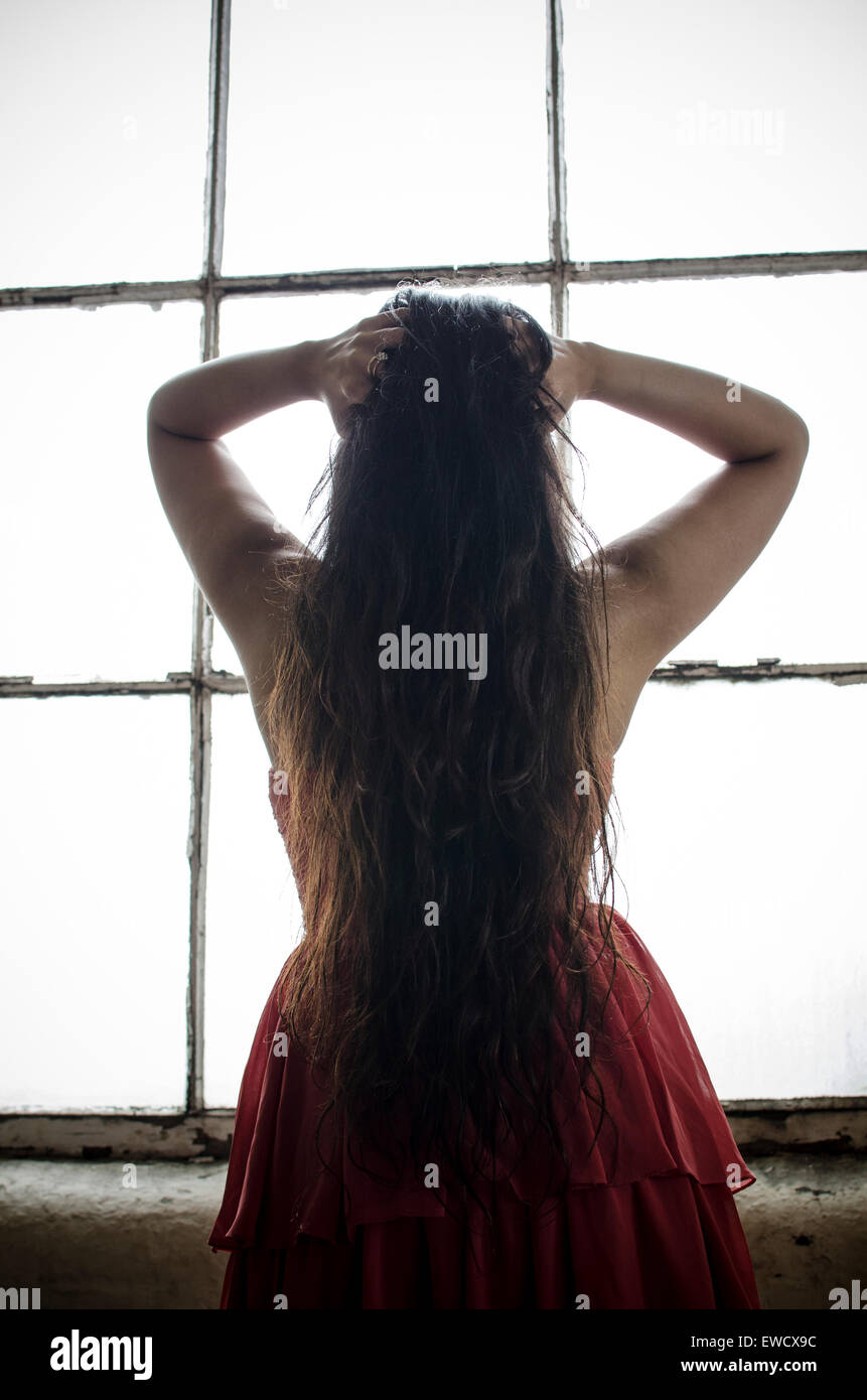 Young woman head in hands by the window Stock Photo - Alamy