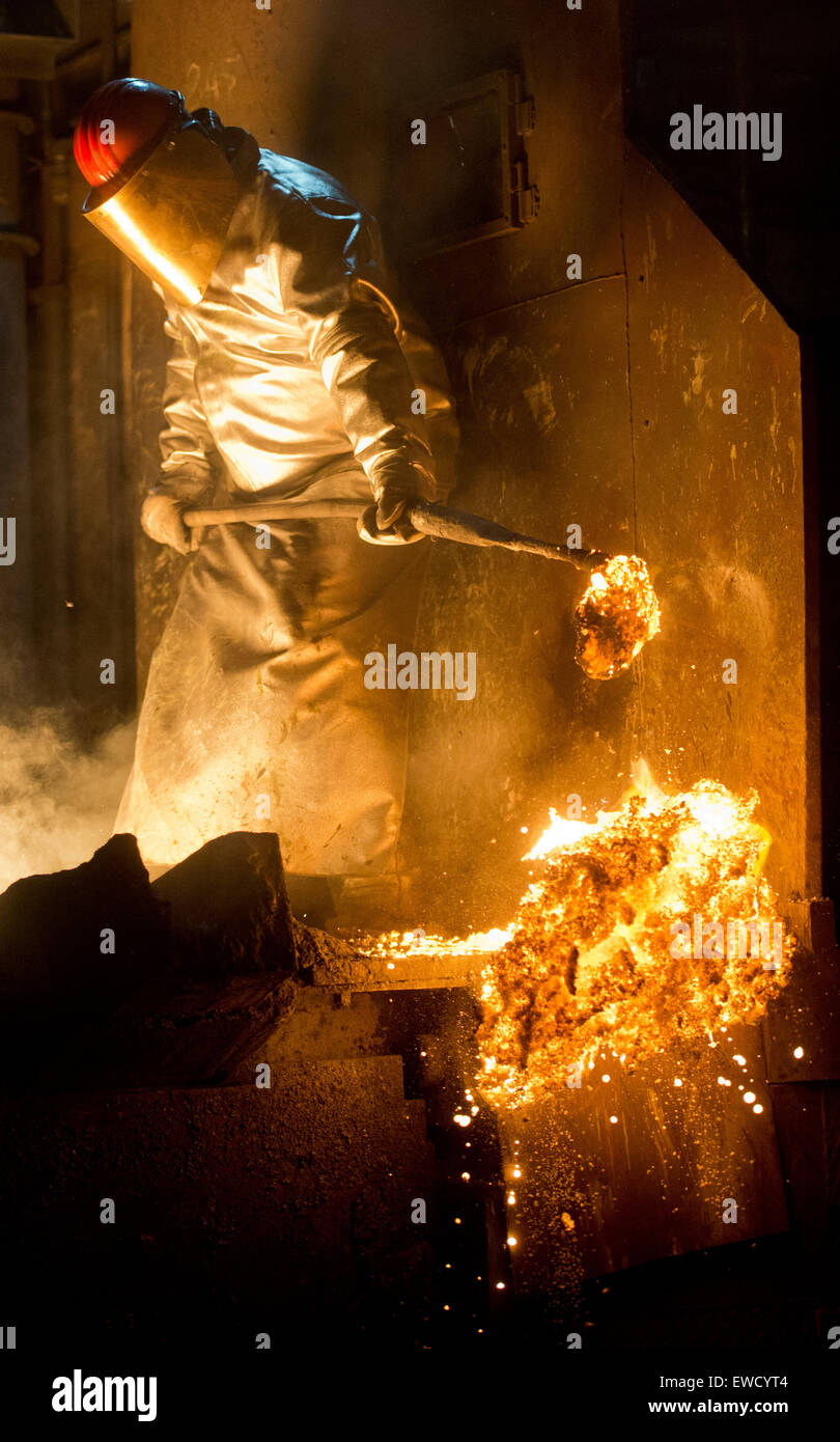 An employee casts liquid iron in the factory of the car parts supplier ...