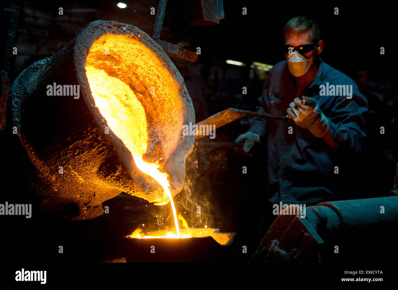 An employee casts liquid iron in the factory of the car parts supplier ...