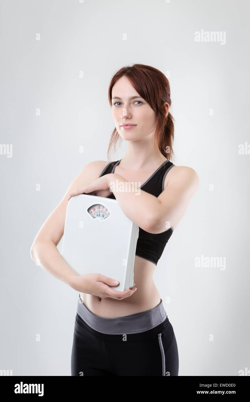 portrait of a young woman holding scales Stock Photo - Alamy