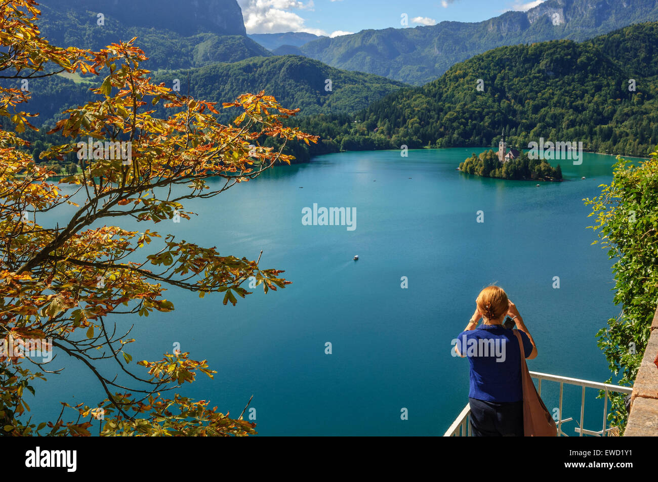 A tourist taking a photograph of lake Bled from Bled castle terrace ...