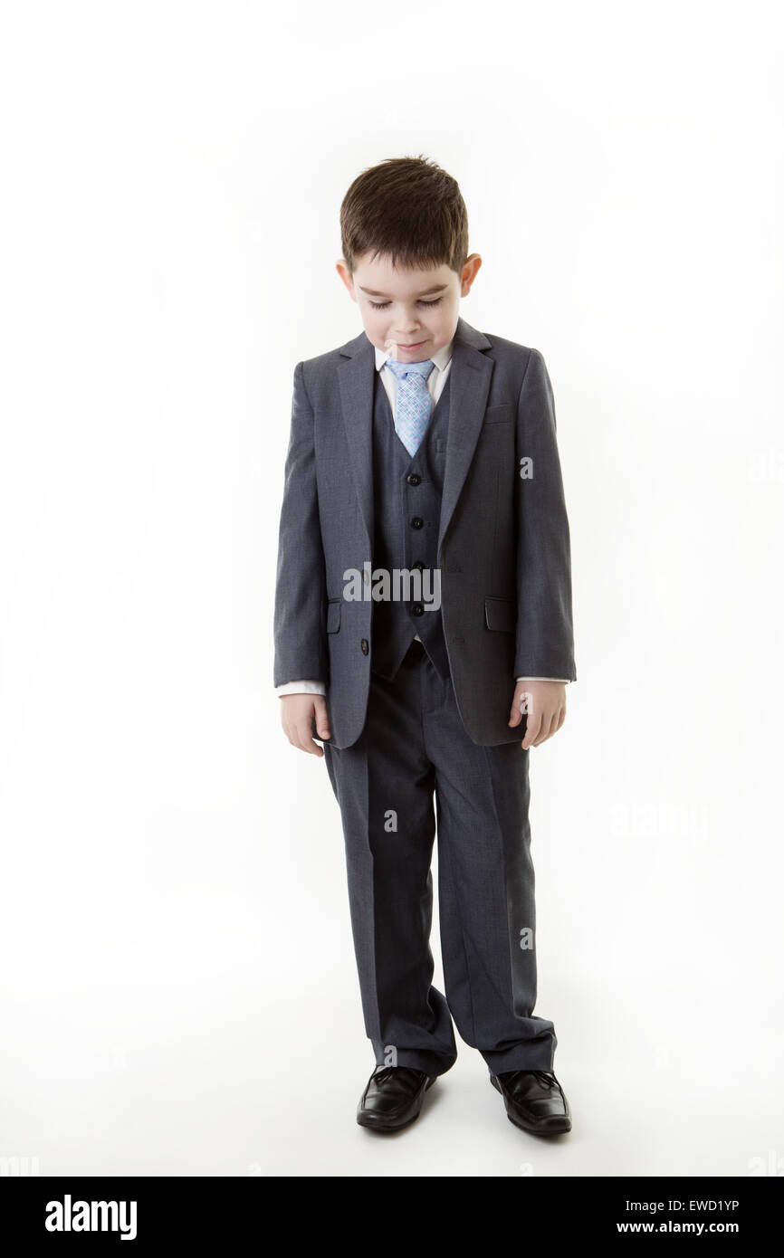 standing young boy dressed up as a business person in a suit looking ...