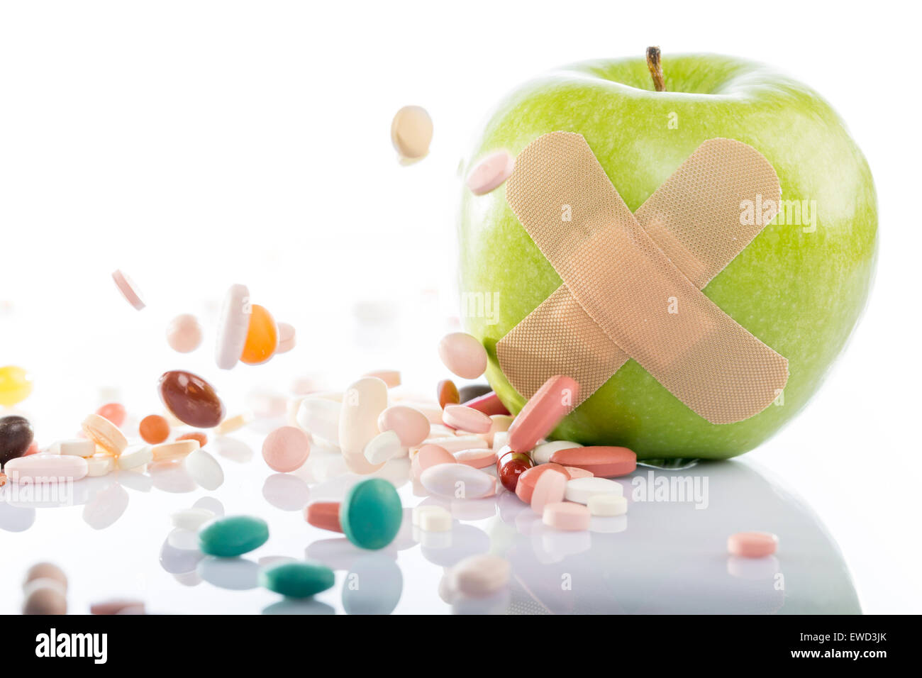 Green apple with a band-aid and various pills on white background Stock ...