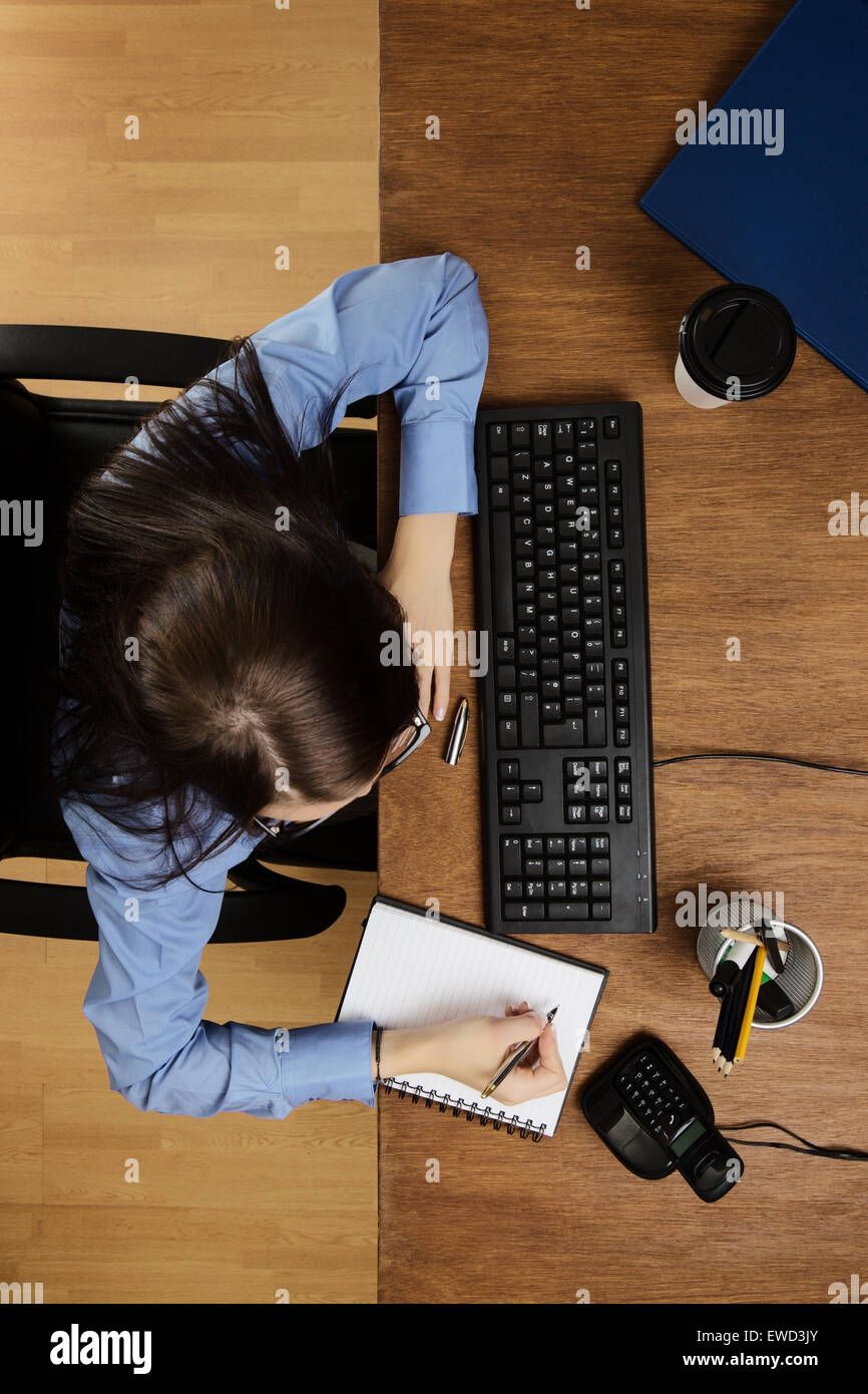 woman typing and working hard at her desk taken from a birds eye view ...