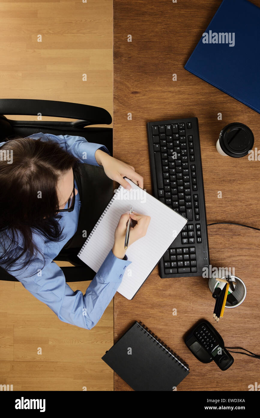 woman typing and working hard at her desk taken from a birds eye view ...