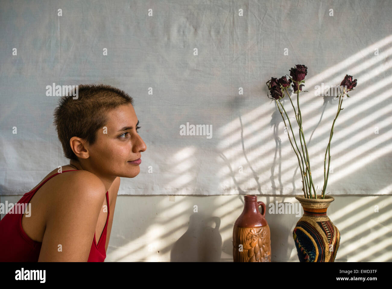 Maryam, young teacher of physics, sits at the table in her apartment in ...