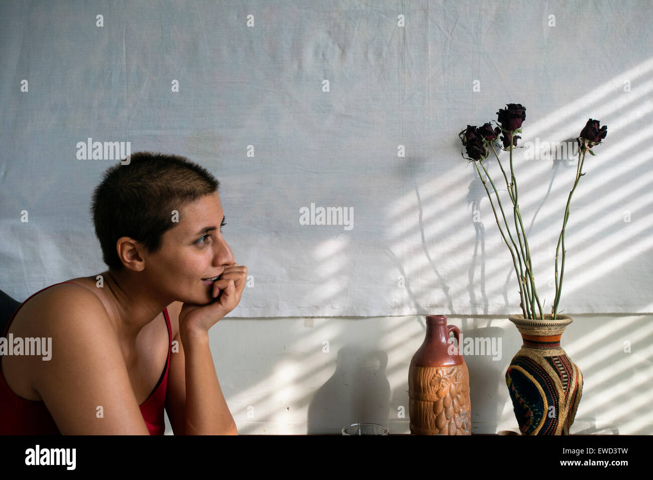 Maryam, young teacher of physics, sits at the table in her apartment in ...