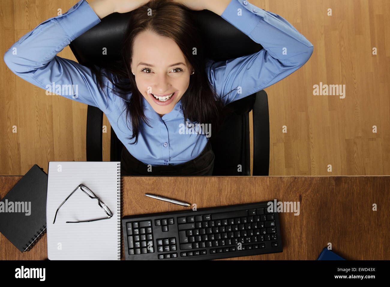 woman at her desk looking up very happy and excited, taken from a birds ...