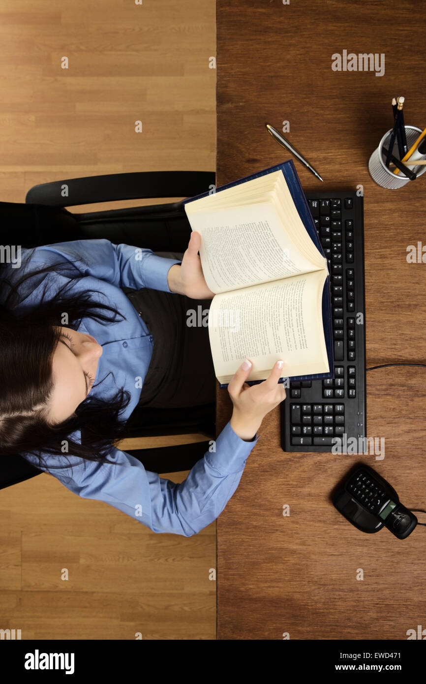 woman at her desk reading a book, taken from a birds eye view Stock ...
