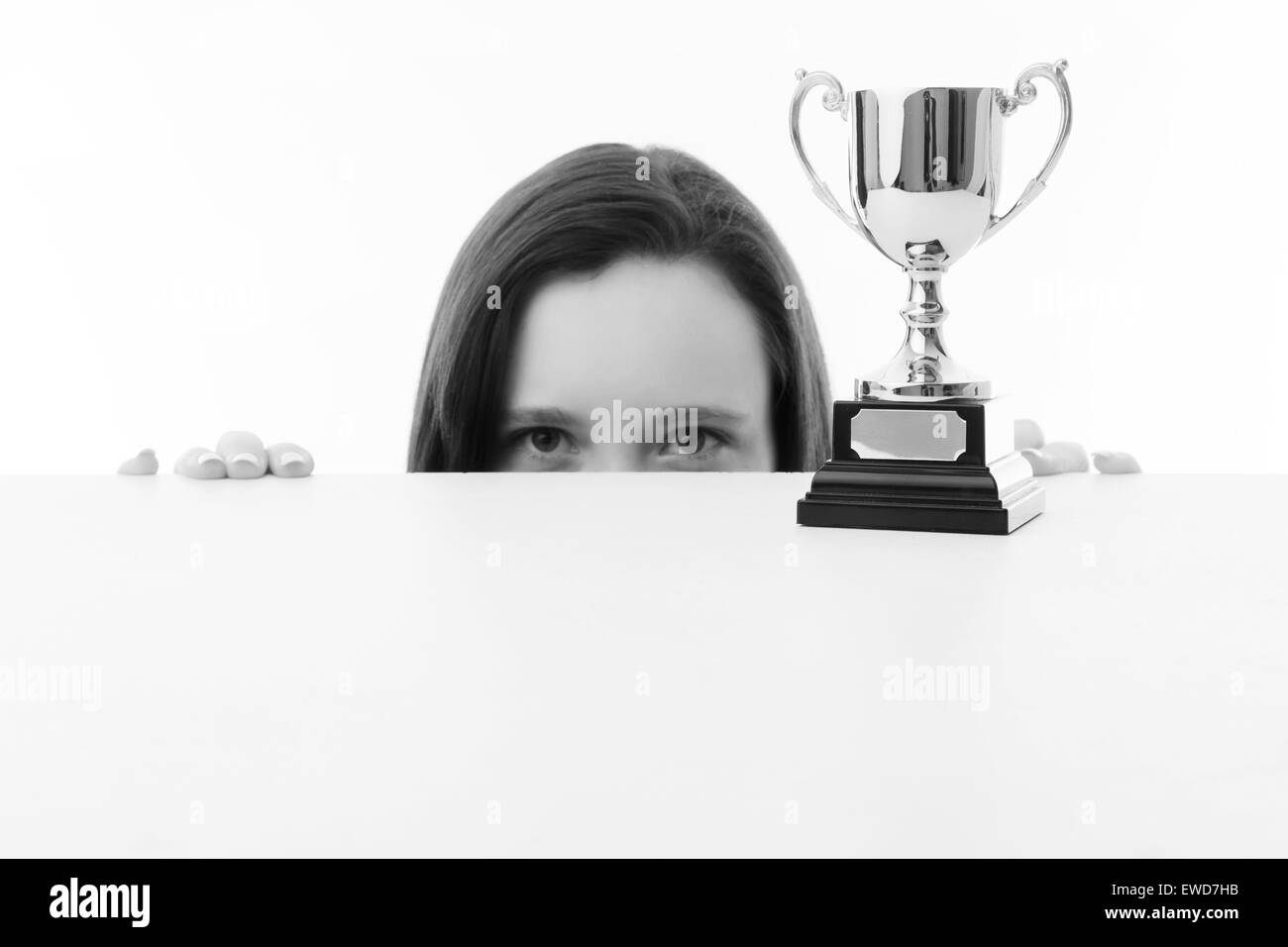 woman peering over a table at a small trophy Stock Photo - Alamy