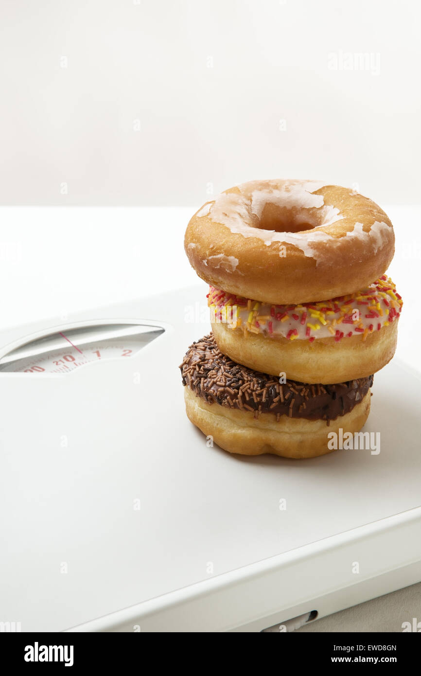 stack of different flavor donuts shot on scale for weighing yourself ...