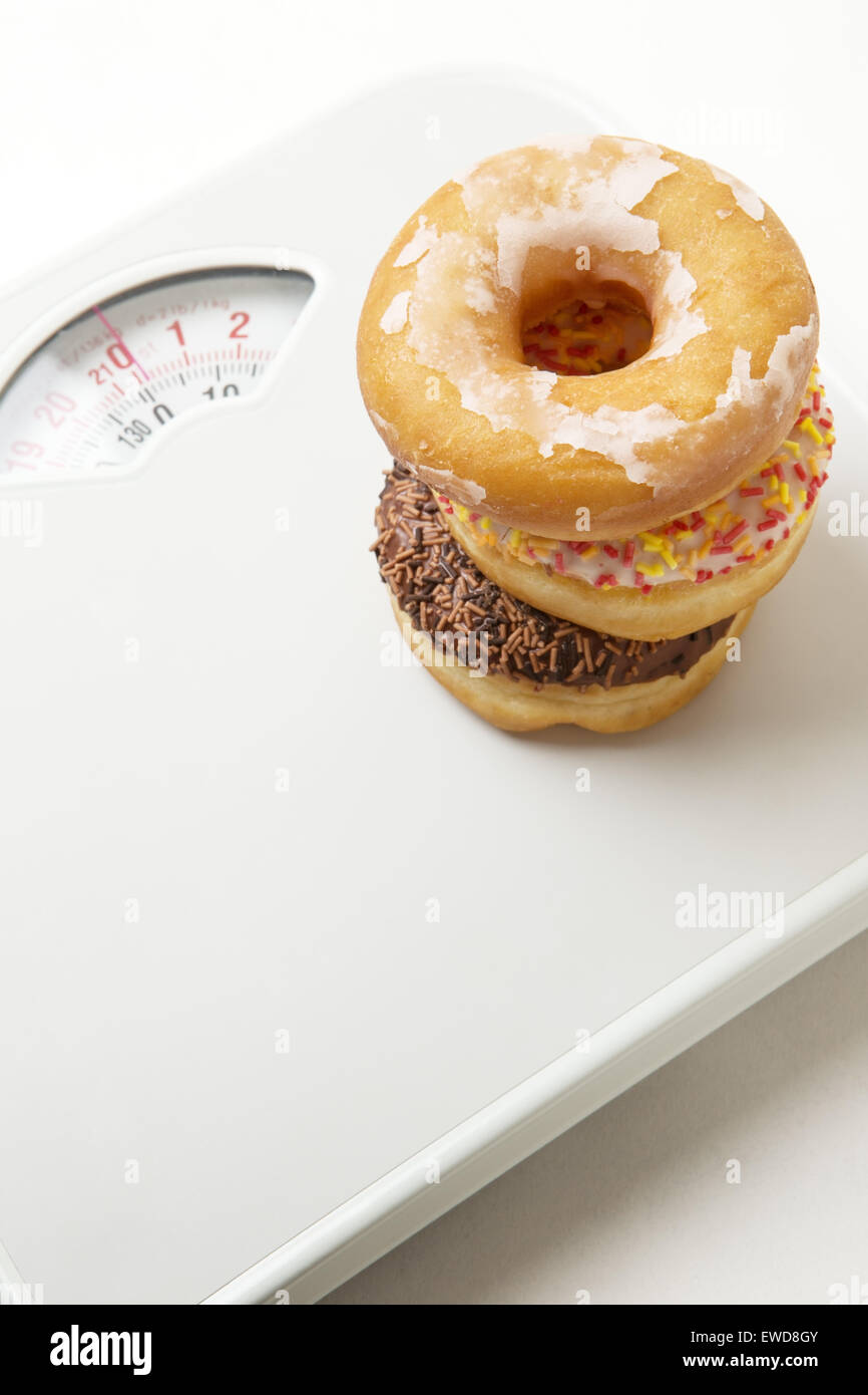 stack of different flavor donuts shot on scale for weighing yourself ...