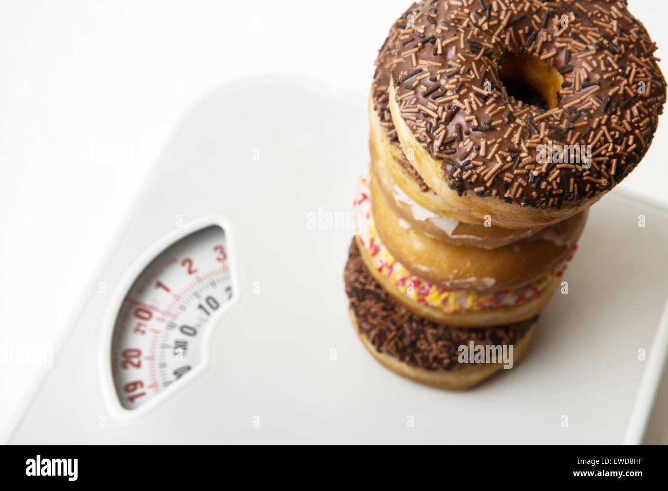 stack of different flavor donuts shot on scale for weighing yourself ...